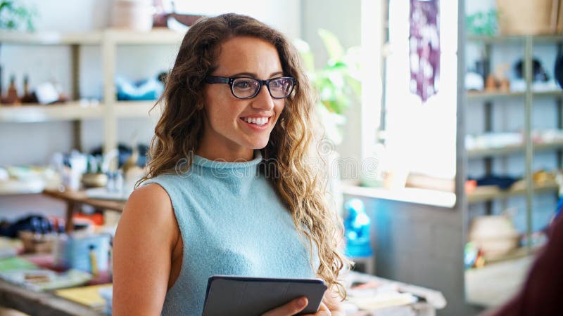 Female Sales Assistant with Digital Tablet Talking with Customer Stock ...