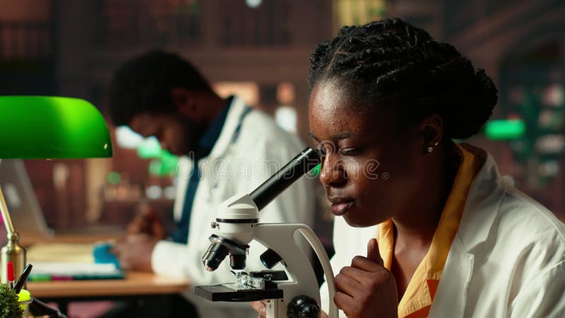 Female Science Student Examines Cells Under Microscope for Scientific ...
