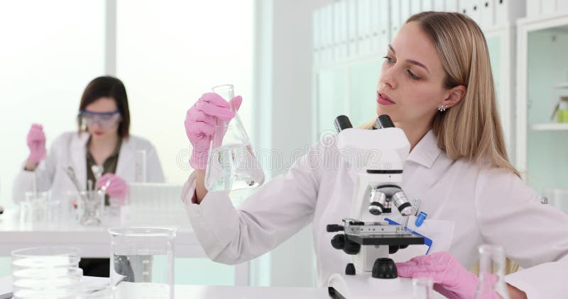 Female Scientist Examines Transparent Liquid Solvent Alcohol in Flask ...