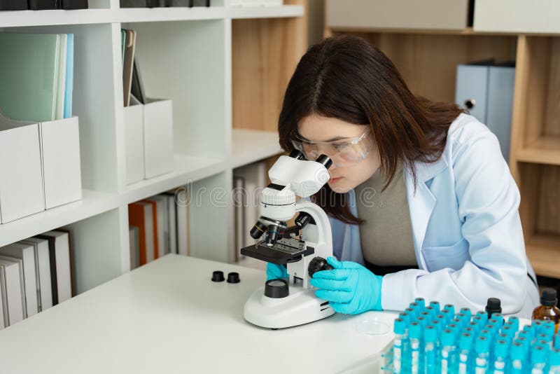 Female Scientist Intently Observing Samples through a Microscope in a ...