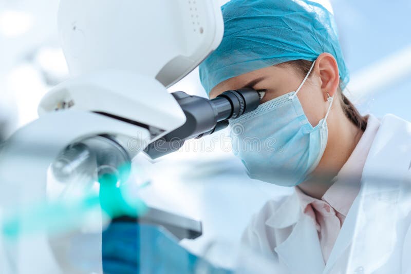 Female Scientist Looking Carefully through a Microscope. Stock Image ...