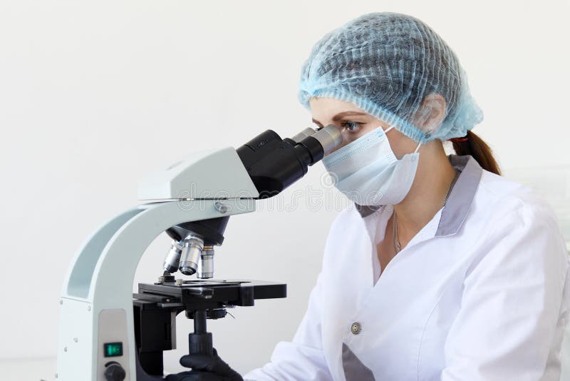 Female Scientist Looking through Microscope in Modern Chemical ...