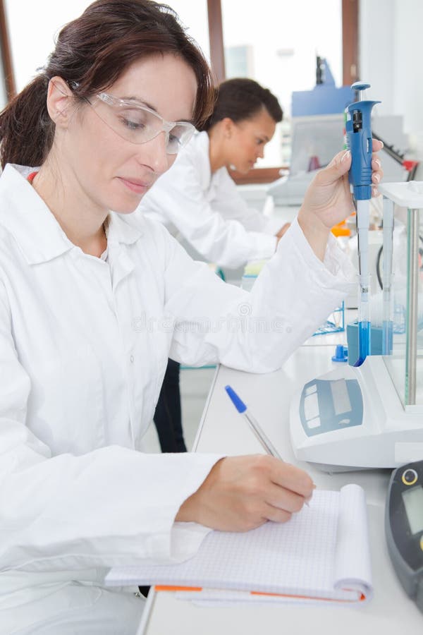 Female Scientist Making Notes As she Conducts Experiment Stock Image ...