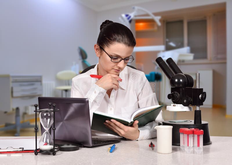 Female Scientist Reading a Book Sitting Stock Photo - Image of micro ...