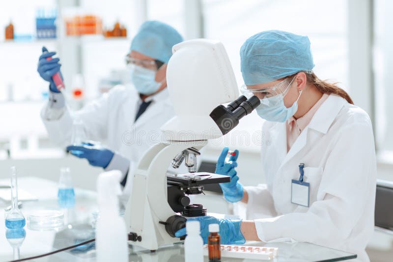 Female Scientist Sitting in Front of a Microscope. Stock Photo - Image ...