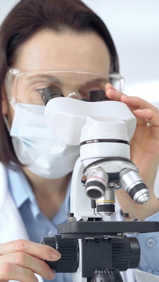 Female Scientist Using Microscope in Laboratory. Focus on a Woman in ...