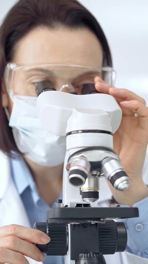 Female Scientist Using Microscope in Laboratory. Focus on a Woman in ...