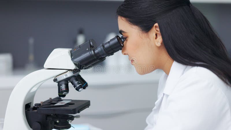 Female Scientist Using a Microscope in a Research Lab. Young Biologist ...