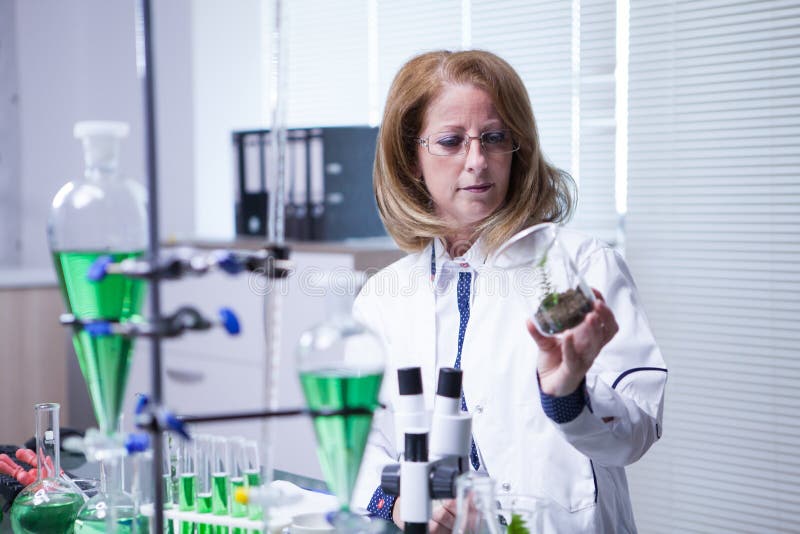 Female Scientist Looking at a Sample of Solution through Stock Photo ...