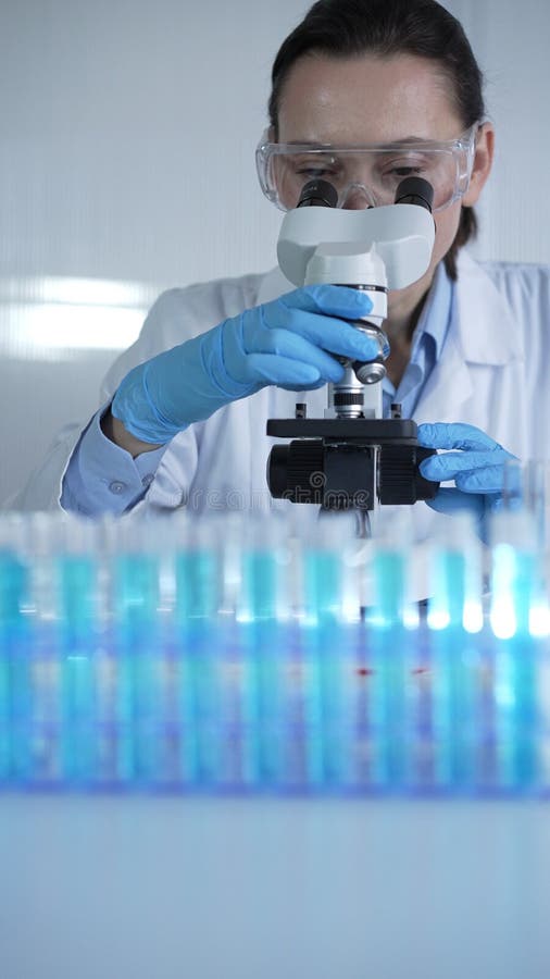 Female Scientist Wearing Lab Coat and Protective Blue Gloves Using ...