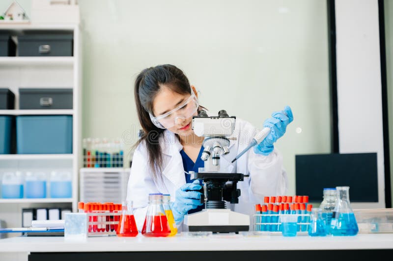 Female Scientist Working with Micro Pipettes Analyzing Biochemical ...