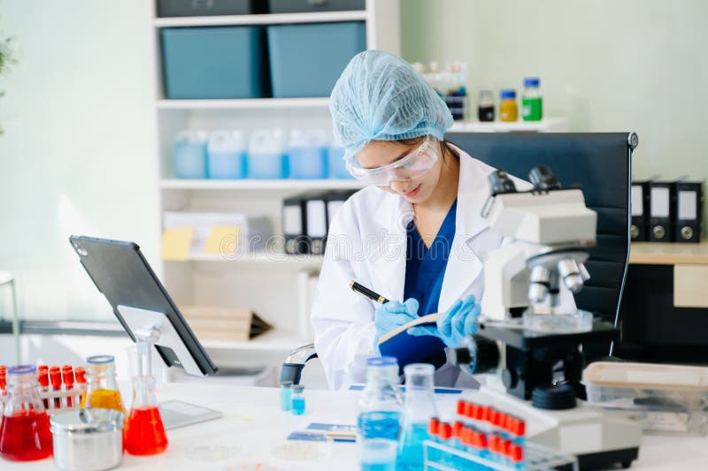 Female Scientist Working with Micro Pipettes Analyzing Biochemical ...