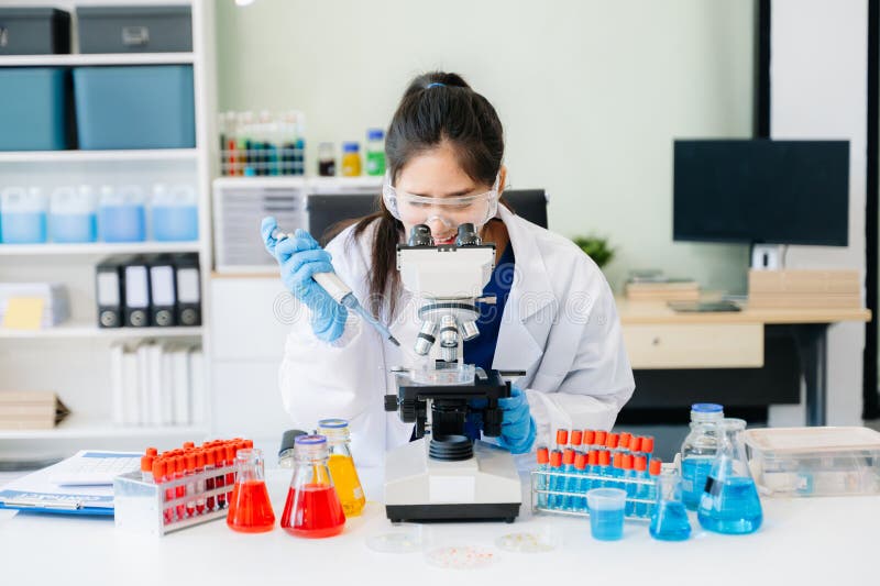 Female Scientist Working with Micro Pipettes Analyzing Biochemical ...