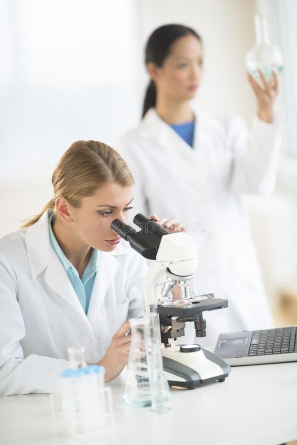 Scientists Using Microscopes and Digital Tablet in Laboratory Stock ... Scientists Using Microscopes and Digital Tablet in Laboratory Stock ...