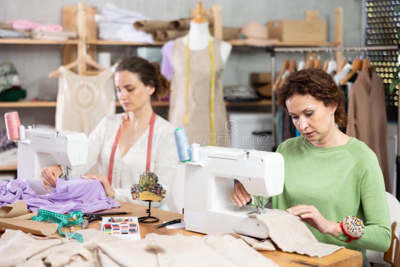 Female Seamstresses Working at Sewing Machines in Tailoring Studio ...