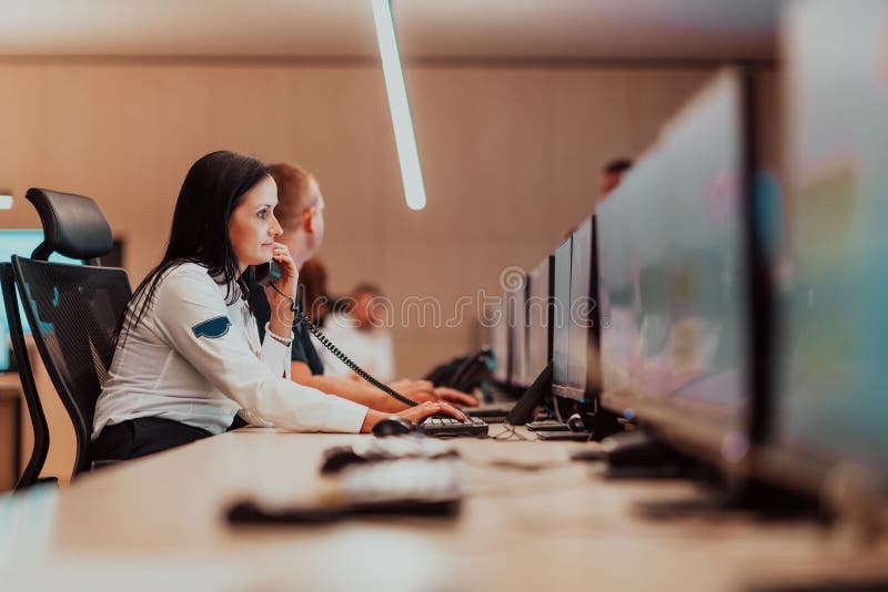 Female Security Guard Operator Talking on the Phone while Working at ...