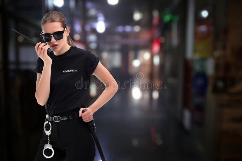 Female Security Guard Using Portable Radio Transmitter in Shopping Mall ...
