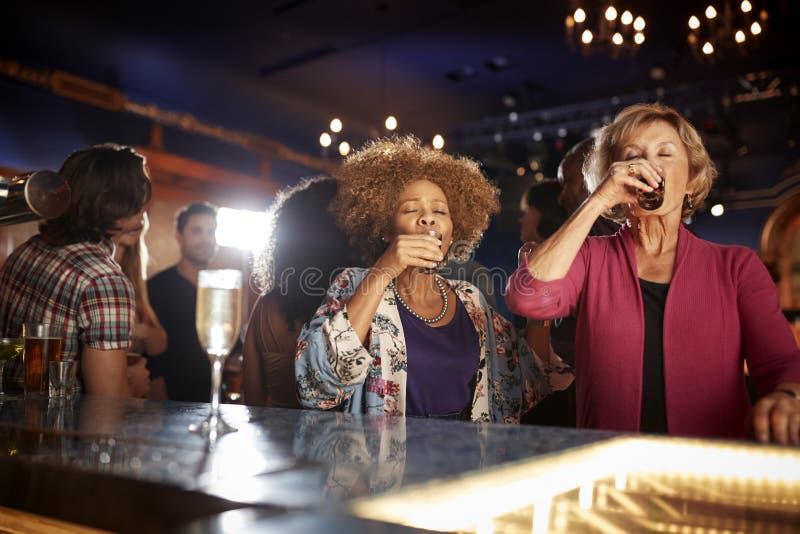 Female Senior Friends Drinking Shots in Bar Together Stock Image ...