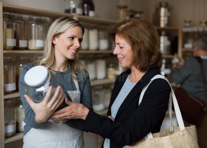 A Female Shop Assistant Serving a Senior Customer in a Zero-waste Shop ...