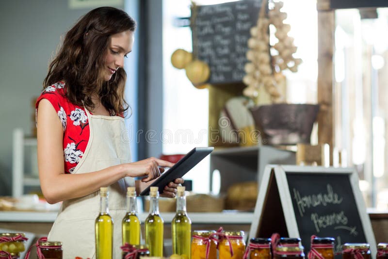 Female Shop Assistant Using Digital Tablet at the Counter Stock Photo ...