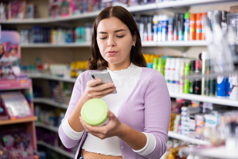 Female Shopper Scanning a QR Code Using a Mobile Phone in Cosmetics ...