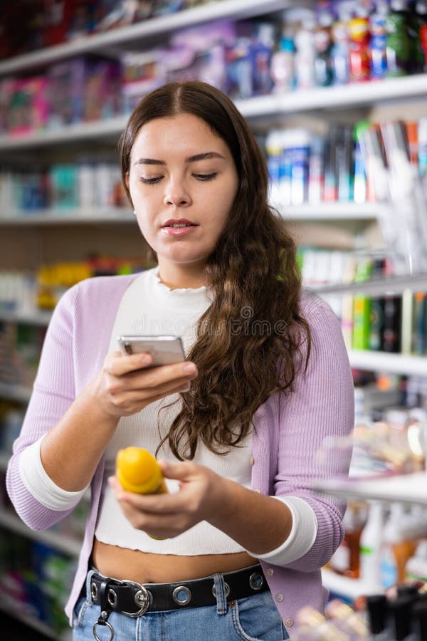 Female Shopper Scanning a QR Code Using a Mobile Phone in Cosmetics ...