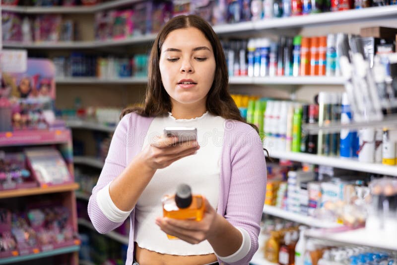 Female Shopper Scanning a QR Code Using a Mobile Phone in Cosmetics ...