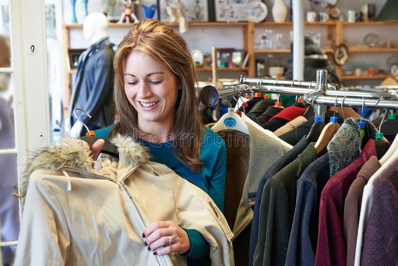 Female Shopper in Thrift Store Looking at Clothes Stock Photo - Image ...