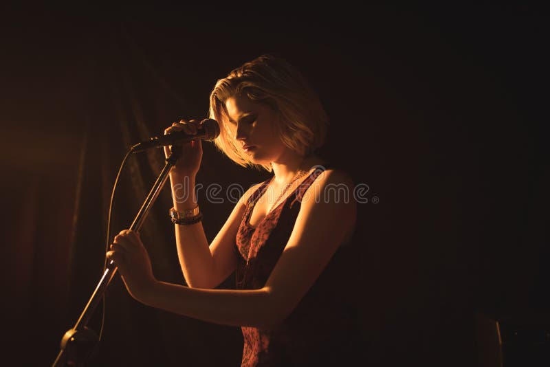 Female Singer Holding Microphone in Nightclub Stock Image - Image of ...