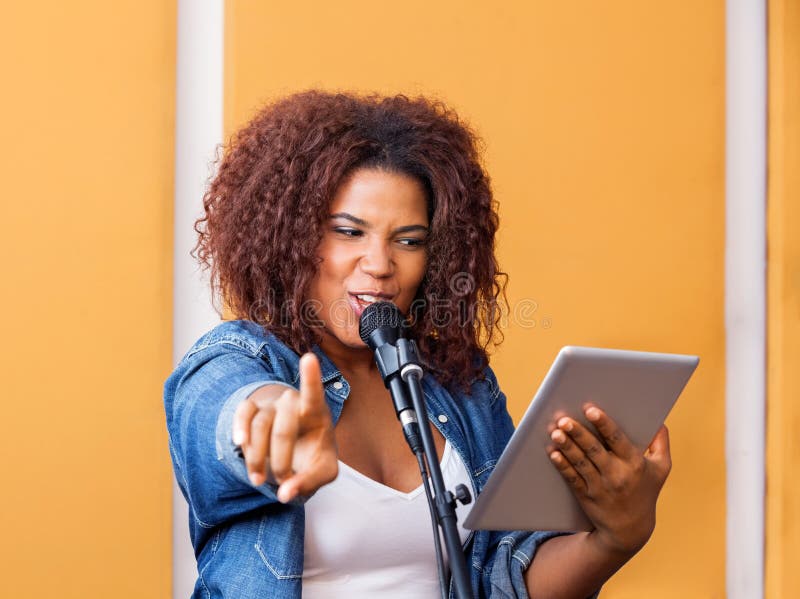 Female Singer Pointing while Holding Digital Tablet Stock Image - Image ...