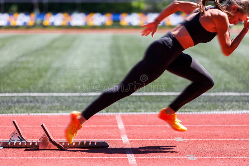 Female Sprinter Launches from the Starting Blocks with Explosive Power ...