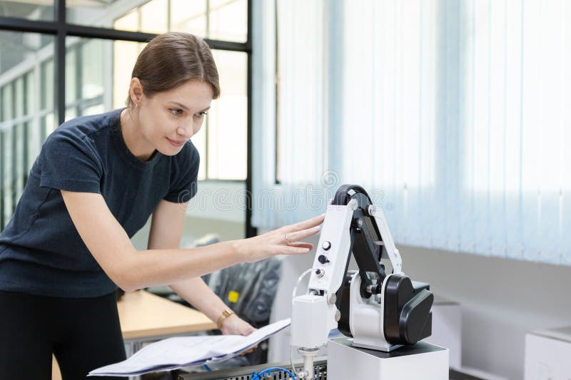 Female Staff Engineer with Robot on Table at Class Room. Education Classroom for Future Robotics ...