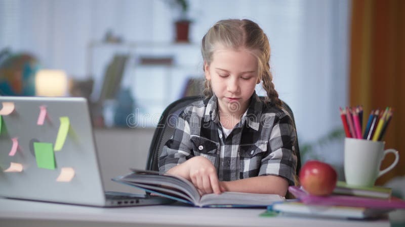 Female Student of Elementary Grades Doing Homework Reading Book at Home ...