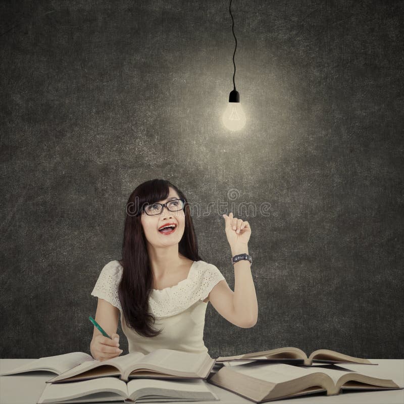 Brilliant Student Pointing at Bright Light Bulb Stock Photo - Image of ...