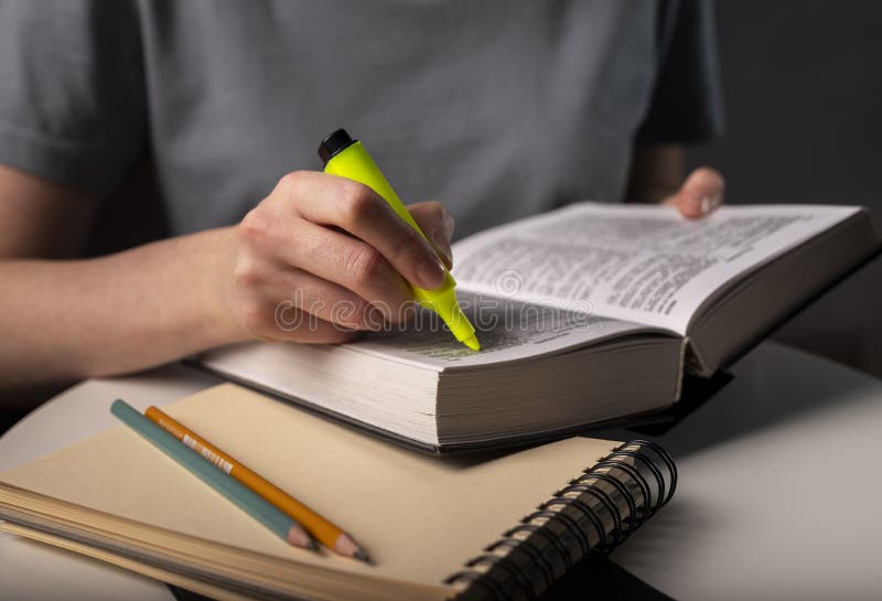 Female Student Hands Holding Yellow Highlighter and Reading Book or ...