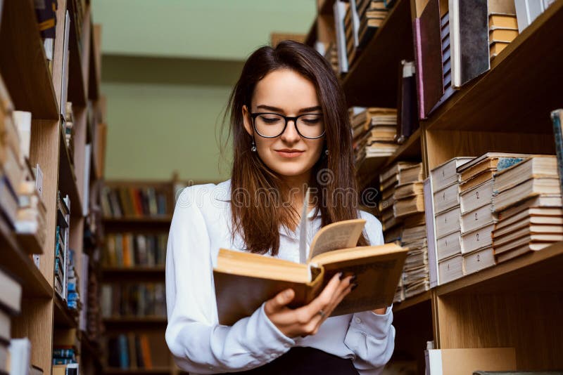 Student at the Library Reading a Book Stock Image - Image of library ...