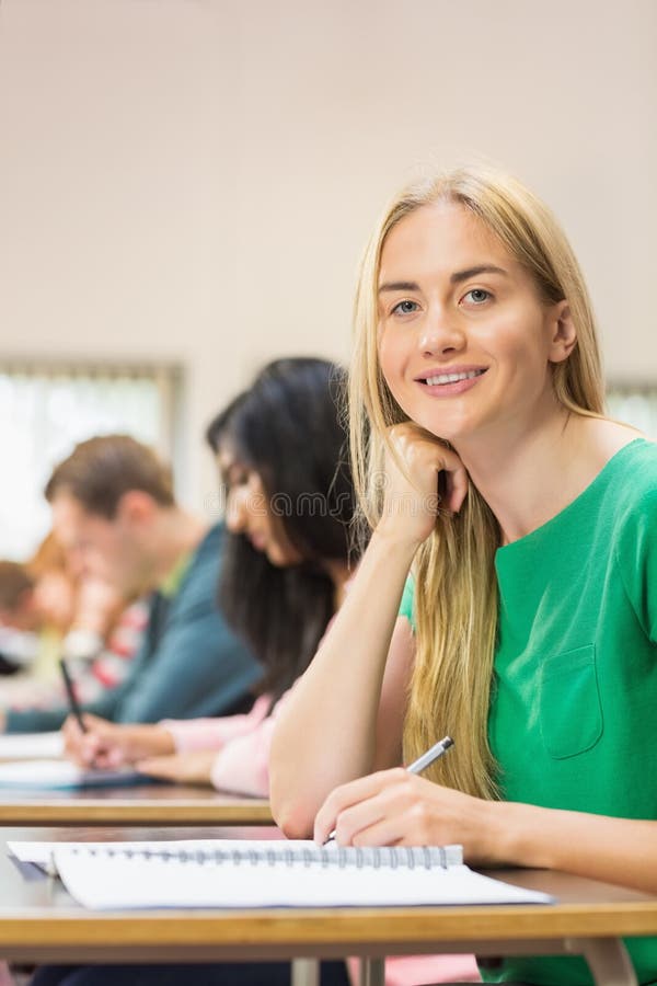 Female Student with Others Writing Notes in Classroom Stock Image ...