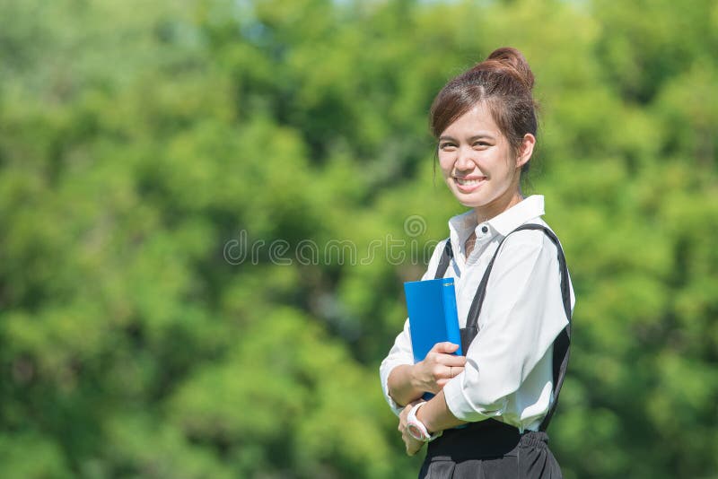 Female Student Outdoors Holding a Notebook and Smiling Stock Photo ...