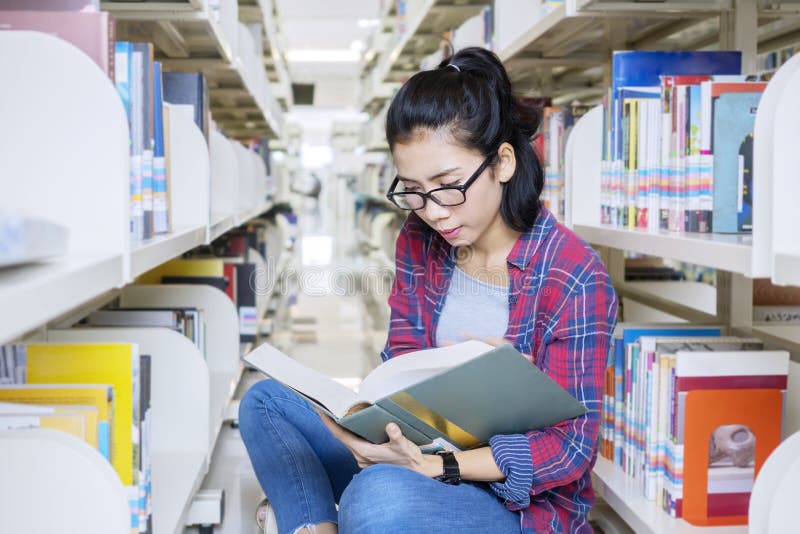 Female Student Reading a Book in the Library Aisle Stock Photo - Image ...