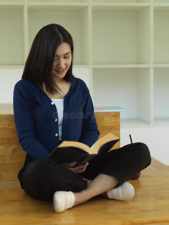 Female Student Reading Book while Sitting on Staircase in Reading ...