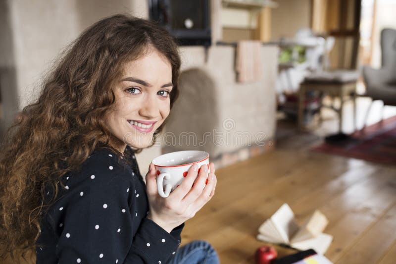 Female Student Sitting on Floor, Drinking Coffee and Studying for Final ...