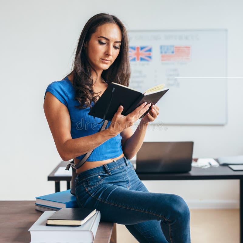 Female Student Sitting at Table Reading Book. Stock Photo - Image of ...