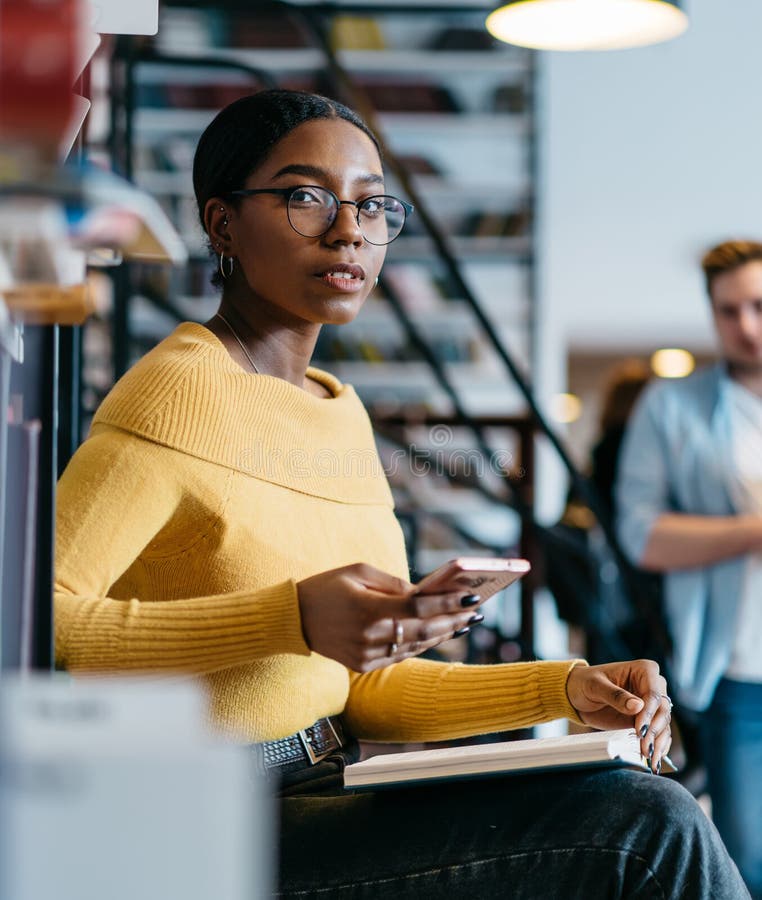 Female Student with Smartphone and Book Sitting in Library Stock Image ...