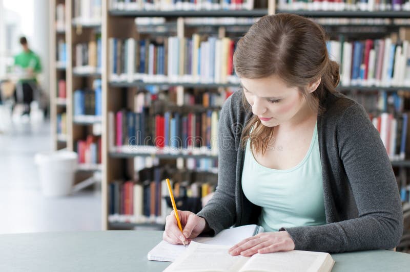 Young Student Girl Concentrated Studying for Exam at College Library ...