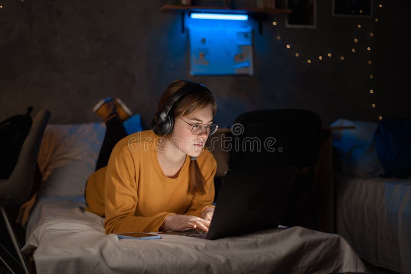 Female Student Studying at Night on Bed in Dorm Room Using Laptop ...