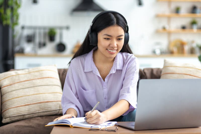 Female Student Studying Remotely Using a Laptop, Taking Notes on ...