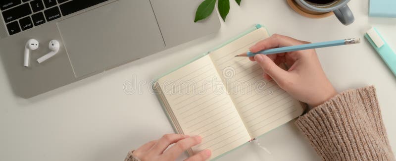 Female Student Taking Note on Blank Notebook while Doing Assignment ...