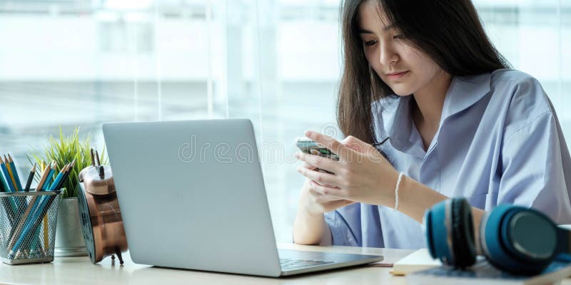 Female Student Taking Notes from a Book and Using Smart Phone at Home ...