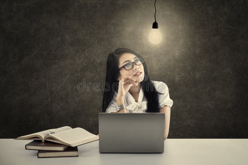 Female Student Thinking Under a Lit Bulb Stock Photo - Image of class ...