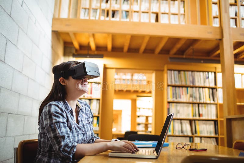 Female Student Using Laptop and Virtual Reality Headset in Library ...